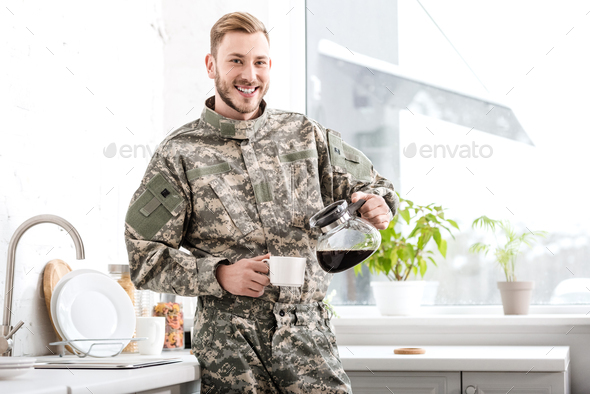 smiling army soldier pouring filtered coffee in kitchen Stock Photo by ...