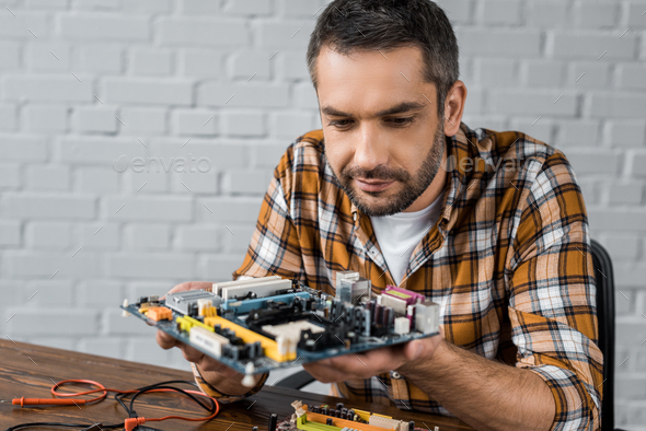 serious handsome computer engineer holding motherboard Stock Photo by ...