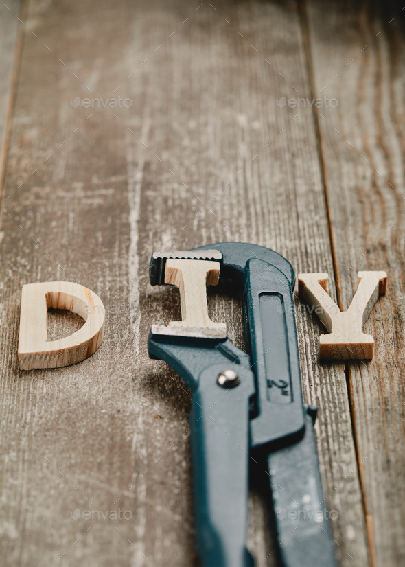 Close up of wooden diy sign and part of pipe wrench on wooden ...