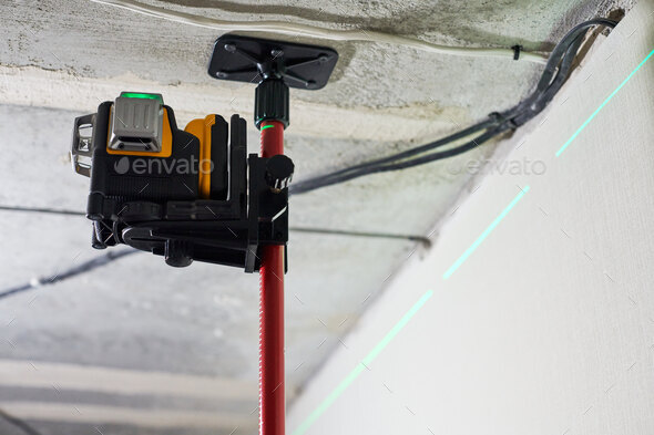 Laser level measuring tool with visible green laser beam on wall for ...