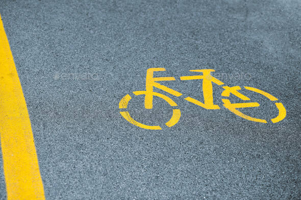 Yellow bicycle sign on sidewalk, road yellow marking for traffic safety ...