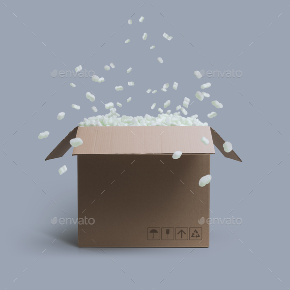 Open delivery box filled with packing chips Stock Photo by stokkete