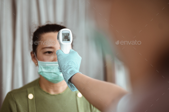 Doctor check patient body temperature using infrared forehead ...