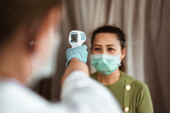 Doctor check patient body temperature using infrared forehead ...