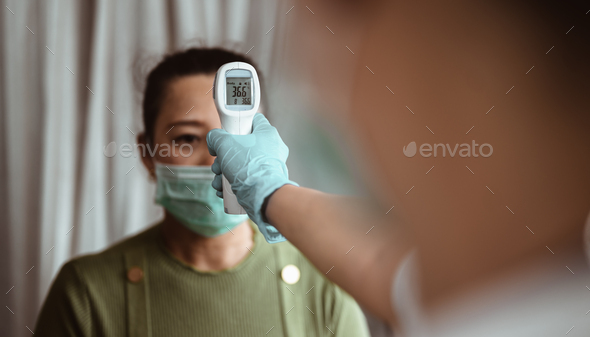 Doctor check patient body temperature using infrared forehead ...