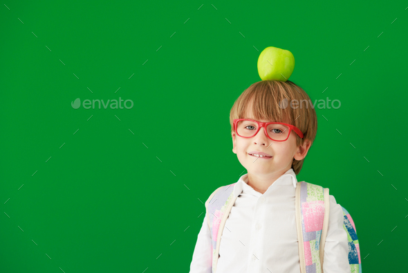 Happy child student against green chalkboard Stock Photo by Sunny_studio