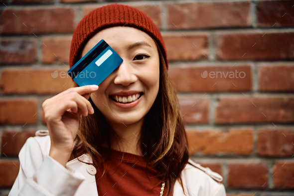 Happy Asian woman having fun with her credit card. Stock Photo by ...