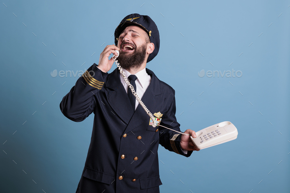 Middle aged airliner captain talking on landline phone Stock Photo by ...