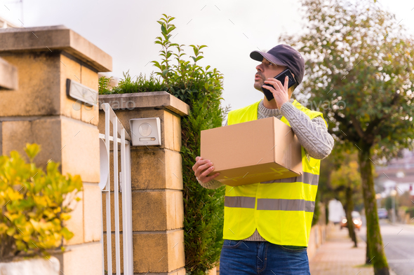 Package delivery carrier with a box from an online store, calling ...