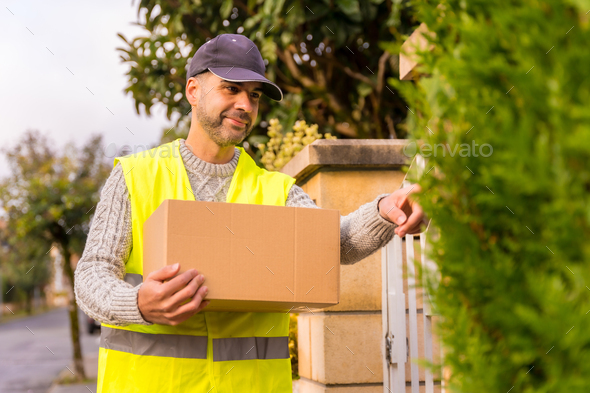 Package delivery carrier with a box from an online store, ringing the ...