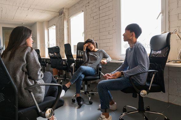 Chinese people having conversation during work Stock Photo by kikea3