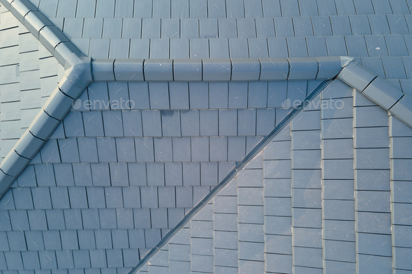 Closeup of house roof top covered with ceramic shingles. Tiled covering ...