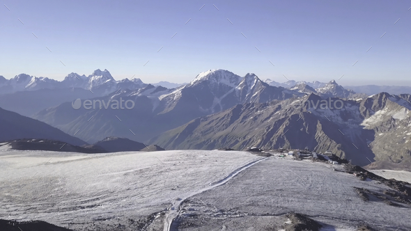 Snowmobiles and houses in snowy mountains. Clip. Top view of snowcats ...