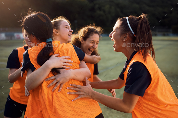 Happy female soccer players celebrating their team's victory on playing ...
