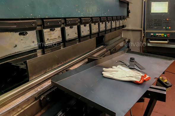 Factory at metal skip machine putting work piece in with sheet metal ...