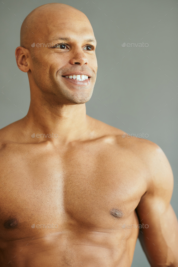 Portrait of young muscular build black man against gray background ...