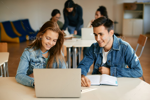 Happy high school students cooperating while e-learning on a computer ...