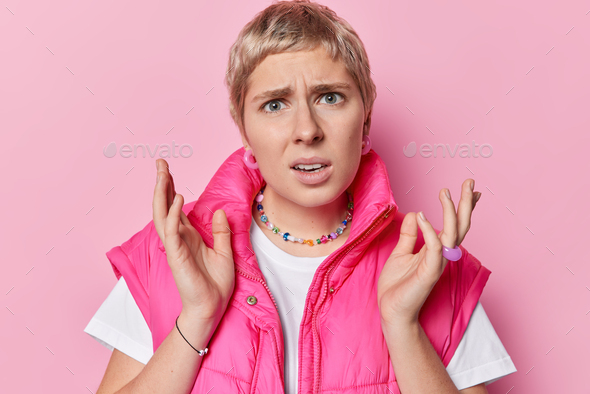 Indoor confused European woman reacts to something unpleasant frowns ...