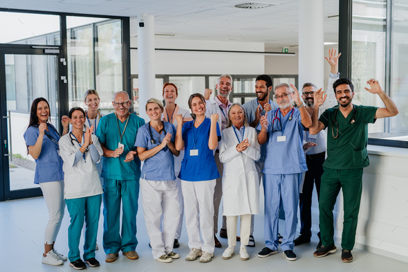 Portrait of happy doctors, nurses and other medical staff clapping in ...