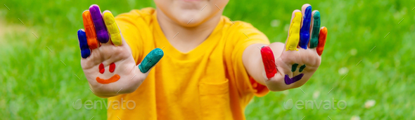 Children's hands in the colors of summer, a smile on the boy's palm ...