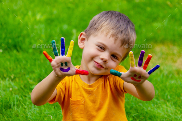 Children's hands in the colors of summer, a smile on the boy's palm ...