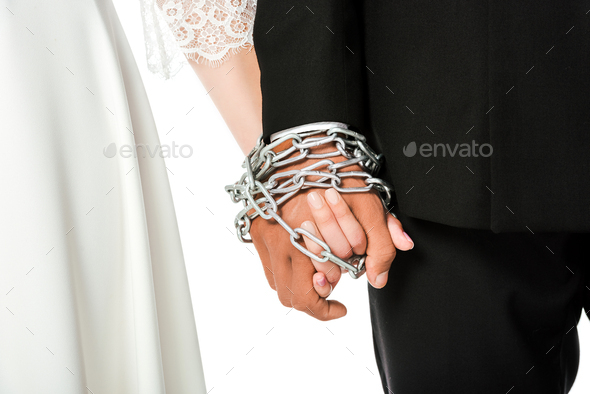 cropped shot of bride and groom holding hands tied in chain isolated on ...