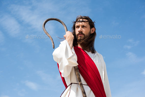 Jesus in robe, red sash and crown of thorns standing with wooden staff ...