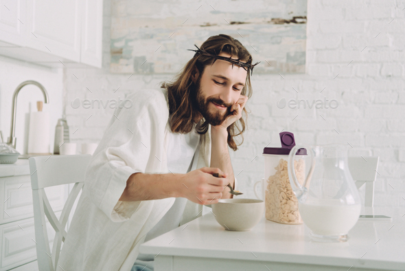 smiling Jesus eating corn flakes on breakfast in kitchen at home Stock ...