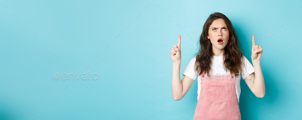 Shocked insulted young woman frowning, gasping and looking with ...