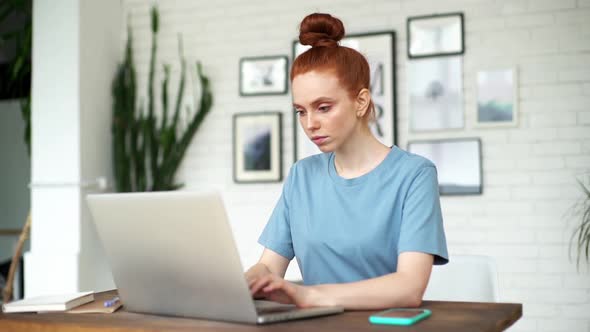 Beautiful Young Redhead Woman Is Working on Laptop at the Desk in Room ...