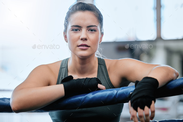 Confident, active and toned female fitness athlete in a boxing ring ...