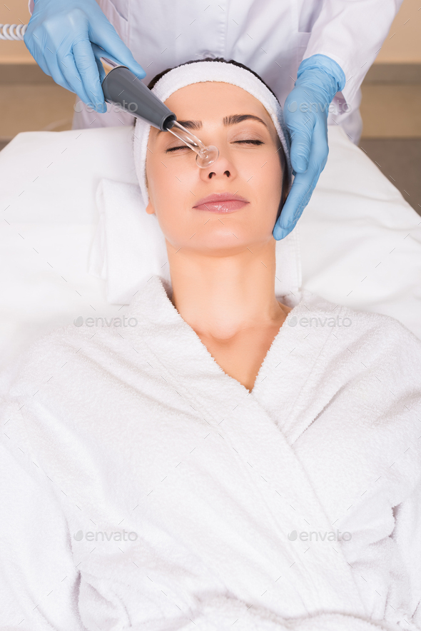 beautician doing darsonvalization to woman nose at beauty salon Stock ...