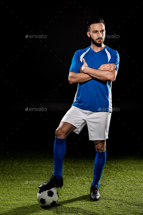 bearded football player standing with ball with crossed arms isolated ...