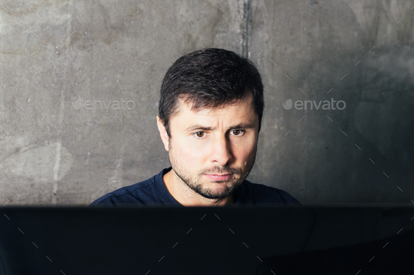 Man at the office desk looking at big computer screen Stock Photo by Bykfa