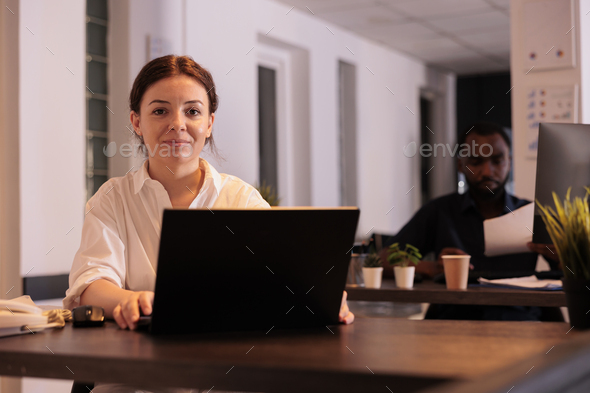Smiling employee working on laptop in coworking space portrait Stock ...