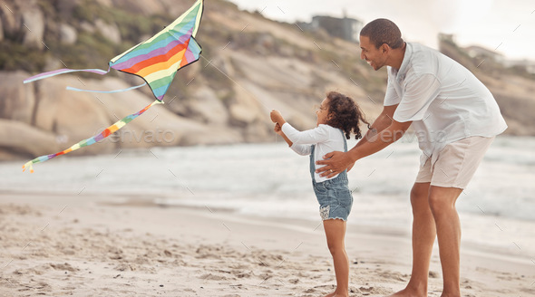 Father teaching child to fly a kite on beach wind with support, love ...