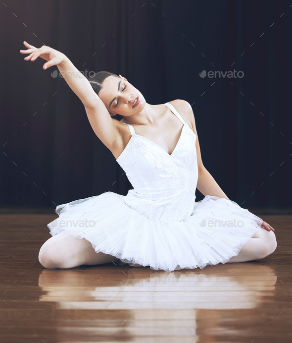 Ballerina sitting on the floor in a studio or on a stage, in a pose ...