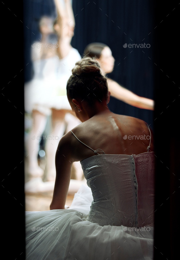 A ballerina backstage of a performance of a theatre on the stage. Sad ...