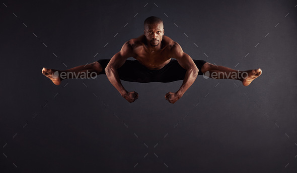 Perfection attained. Male dancer performing the splits in mid-air ...