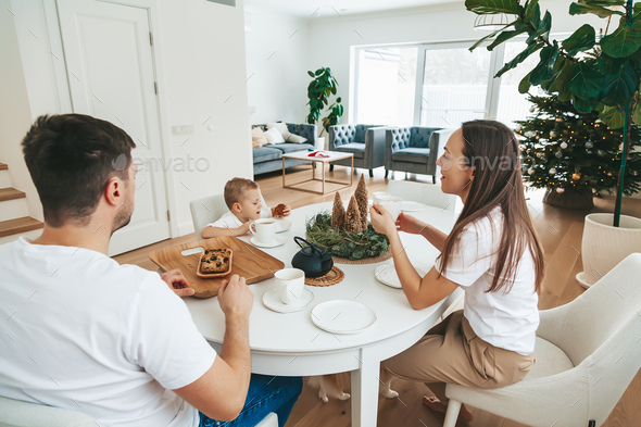 Family sitting around the table on a Christmas morning Stock Photo by ...