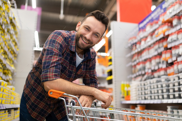 happy customer with a smile on his face next to a shopping basket in a ...