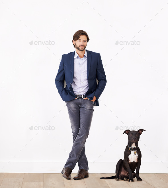 Proud of his canine sidekick. A handsome man standing next to his dog ...