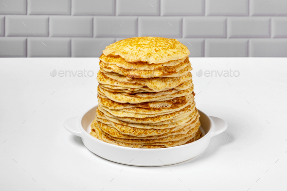 Stack of freshly baked pancakes lie in white ceramic form. Stock Photo ...