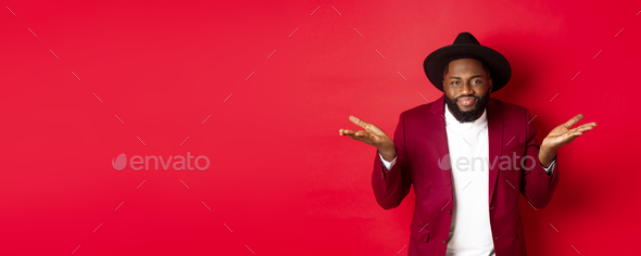 Clueless and unbothered Black man shrugging with indifferent look, dont ...