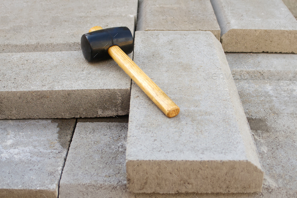 paving hammer. Stack of paving stones. Garden brick pathway paving by ...
