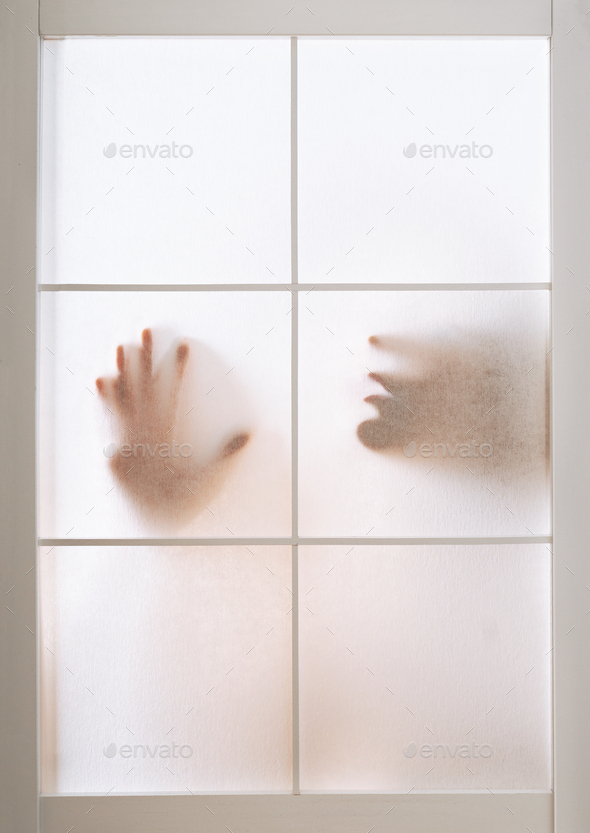silhouette of woman pressing hand and face against transparent screen ...