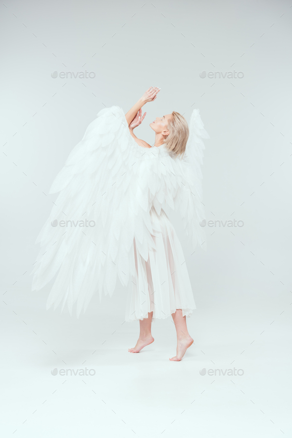 beautiful tender woman with angel wings gesturing with hands and posing ...