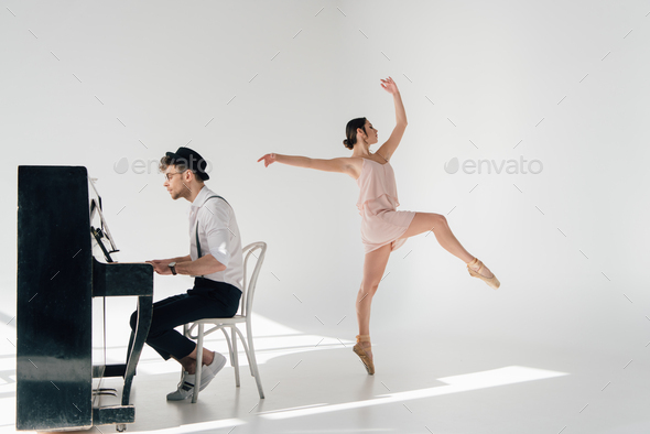handsome pianist playing piano while young ballerina dancing in pink ...