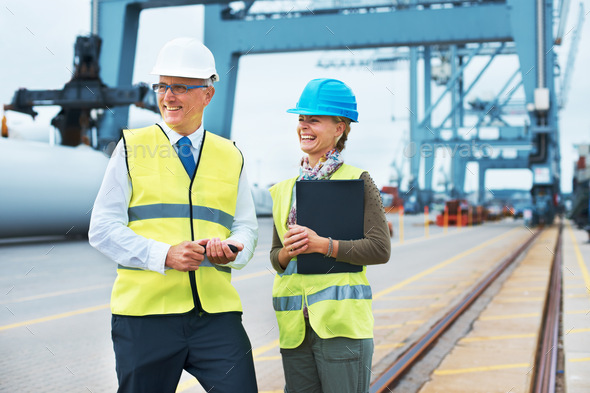 Two dock workers standing together and smiling while on the job Stock ...