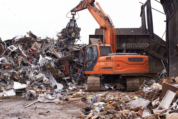 The scrapyard. Cropped shot of an excavator sorting through a pile of ...